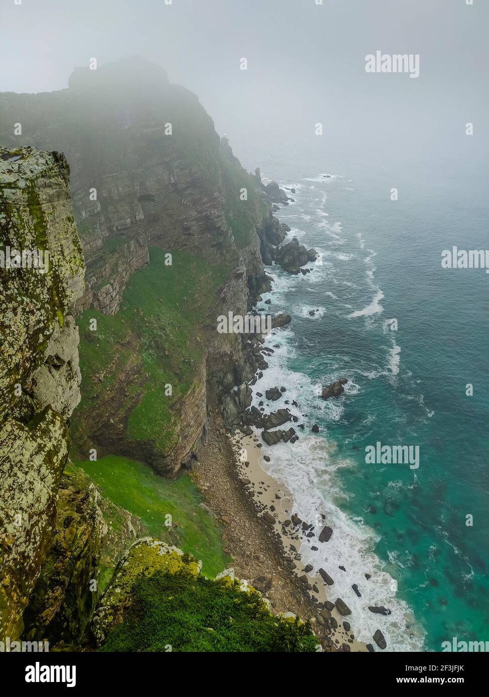 A vertical shot of cliff by the sea surro Stock Photo - Alamy