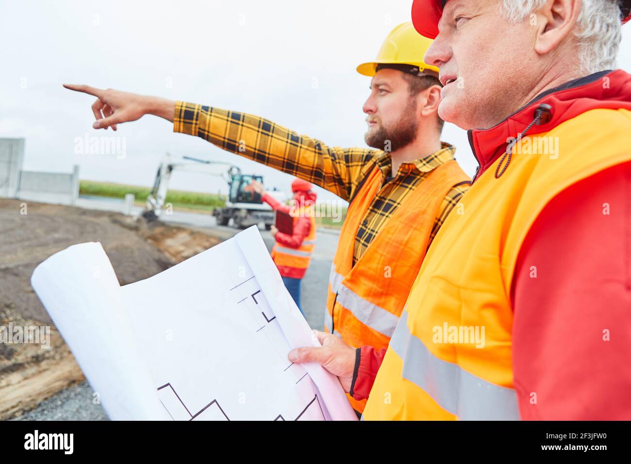 Architect and site manager with floor plan on the construction site of ...