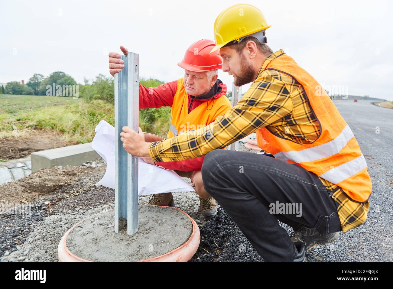 Construction workers check the construction and foundation on the road ...