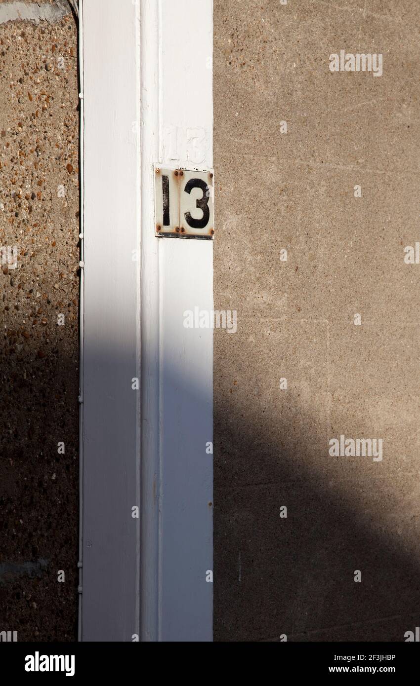 House number thirteen on pebble dashed wall Stock Photo - Alamy