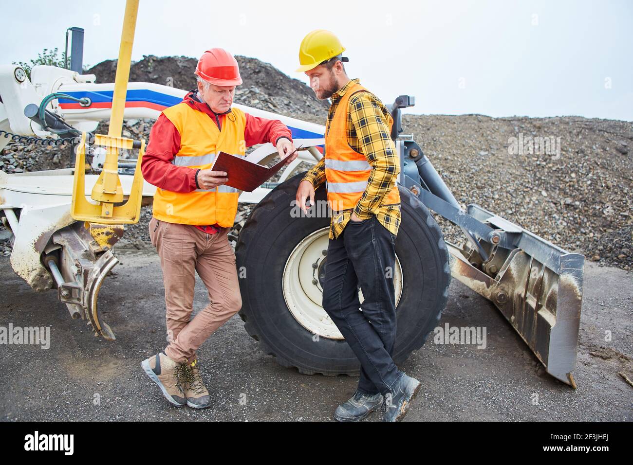 Architect and foreman with construction documents on construction site ...
