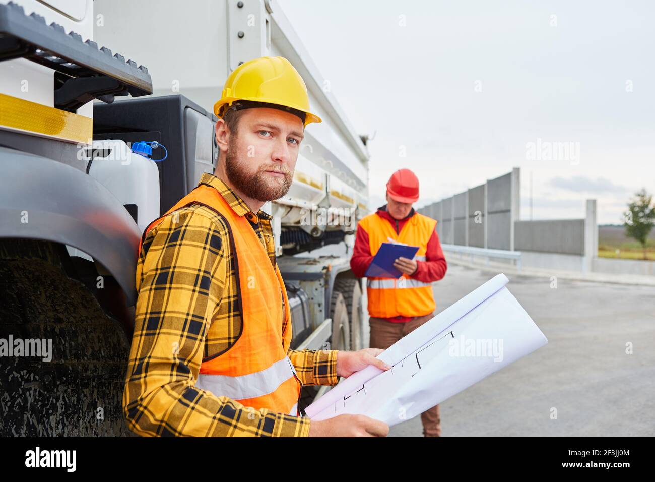 Construction worker with site plan on construction site of road ...