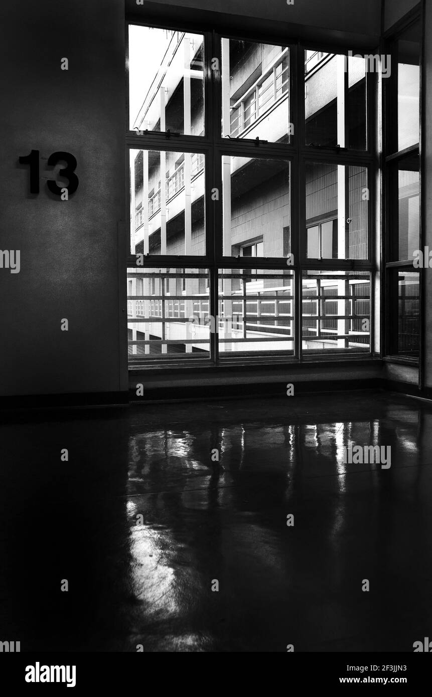 a grayscale shot of the thirteenth floor of a building with large ...