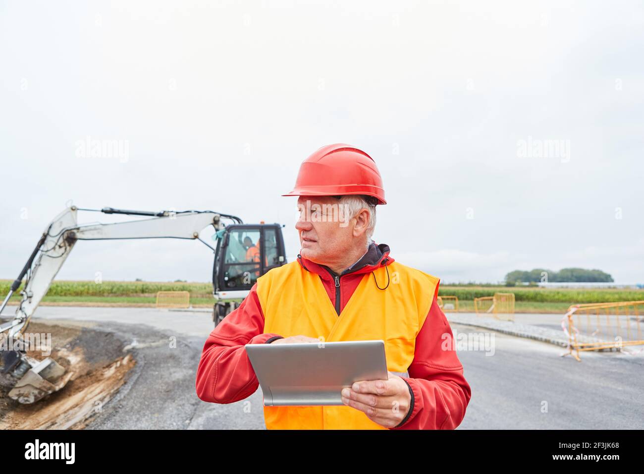 Construction worker with tablet computer on construction site in road ...