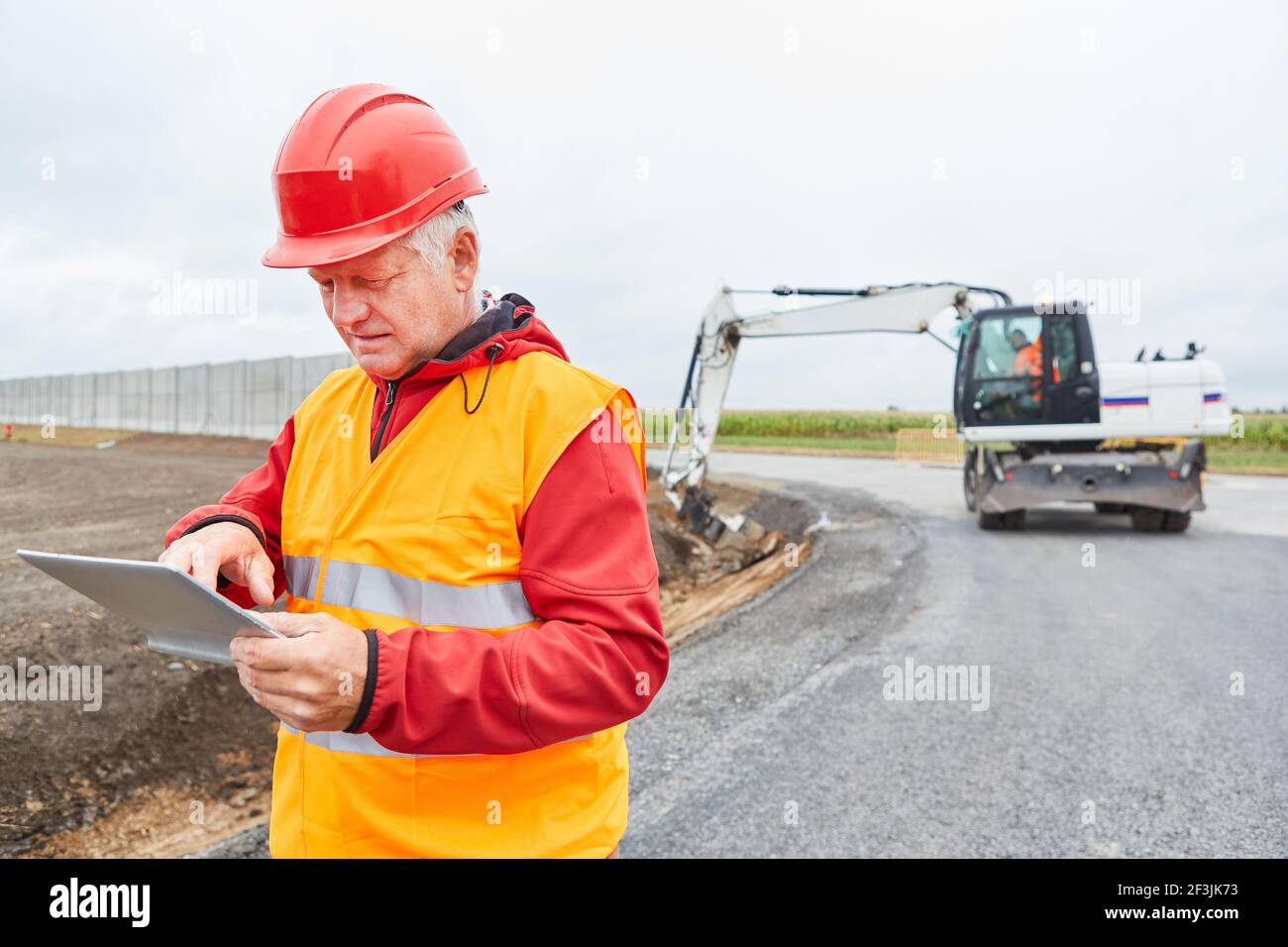 Construction worker using tablet computer during construction planning ...