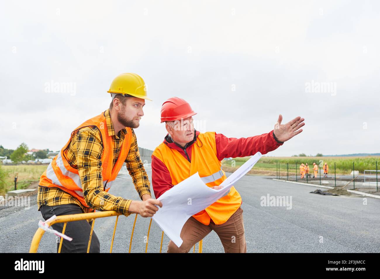 Construction worker and architect with site plan for building on the ...