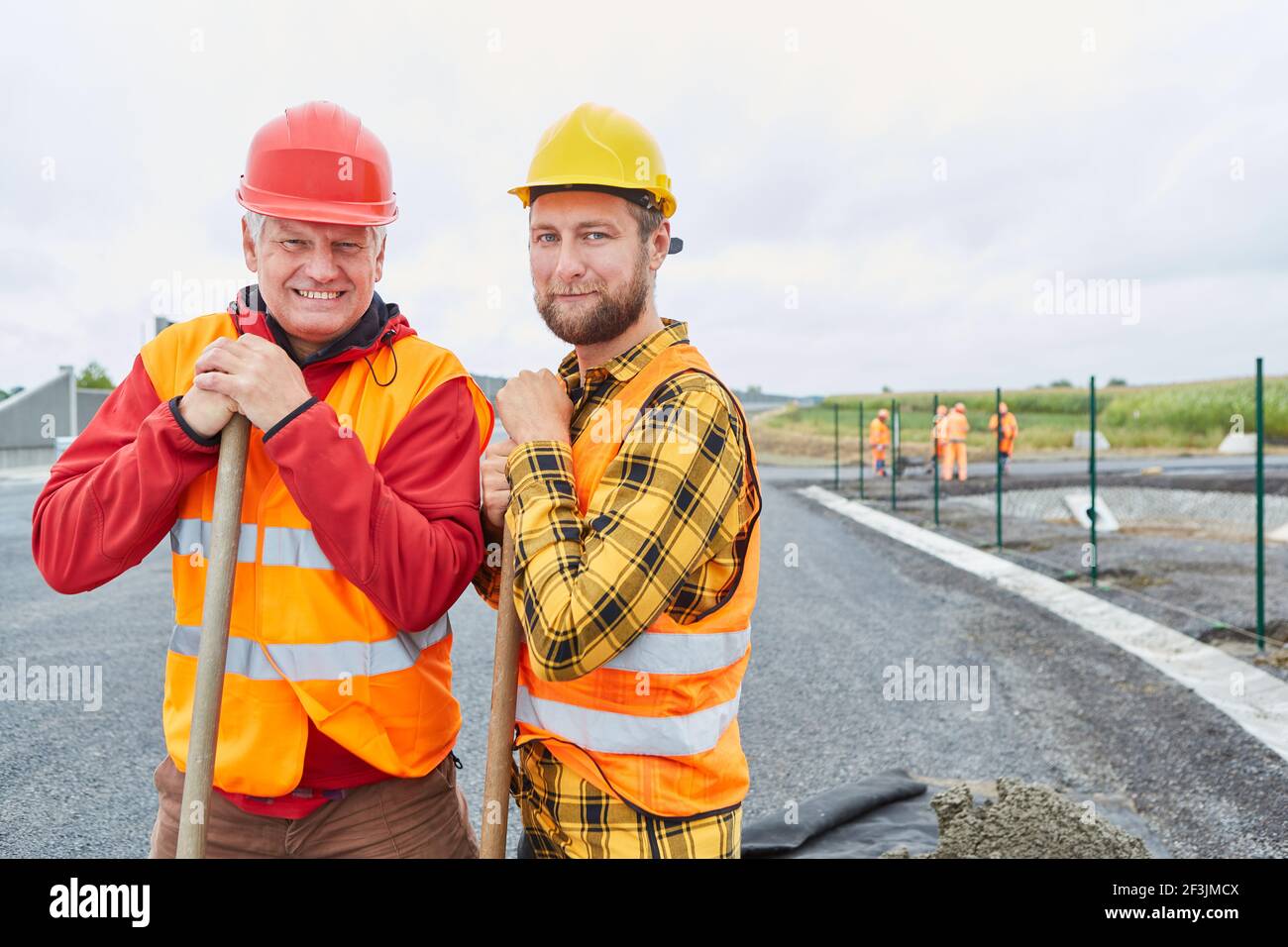 Two workers as road builders on the construction site of the road ...