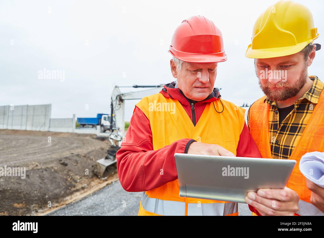 Two workers as a road construction team on a road construction site ...