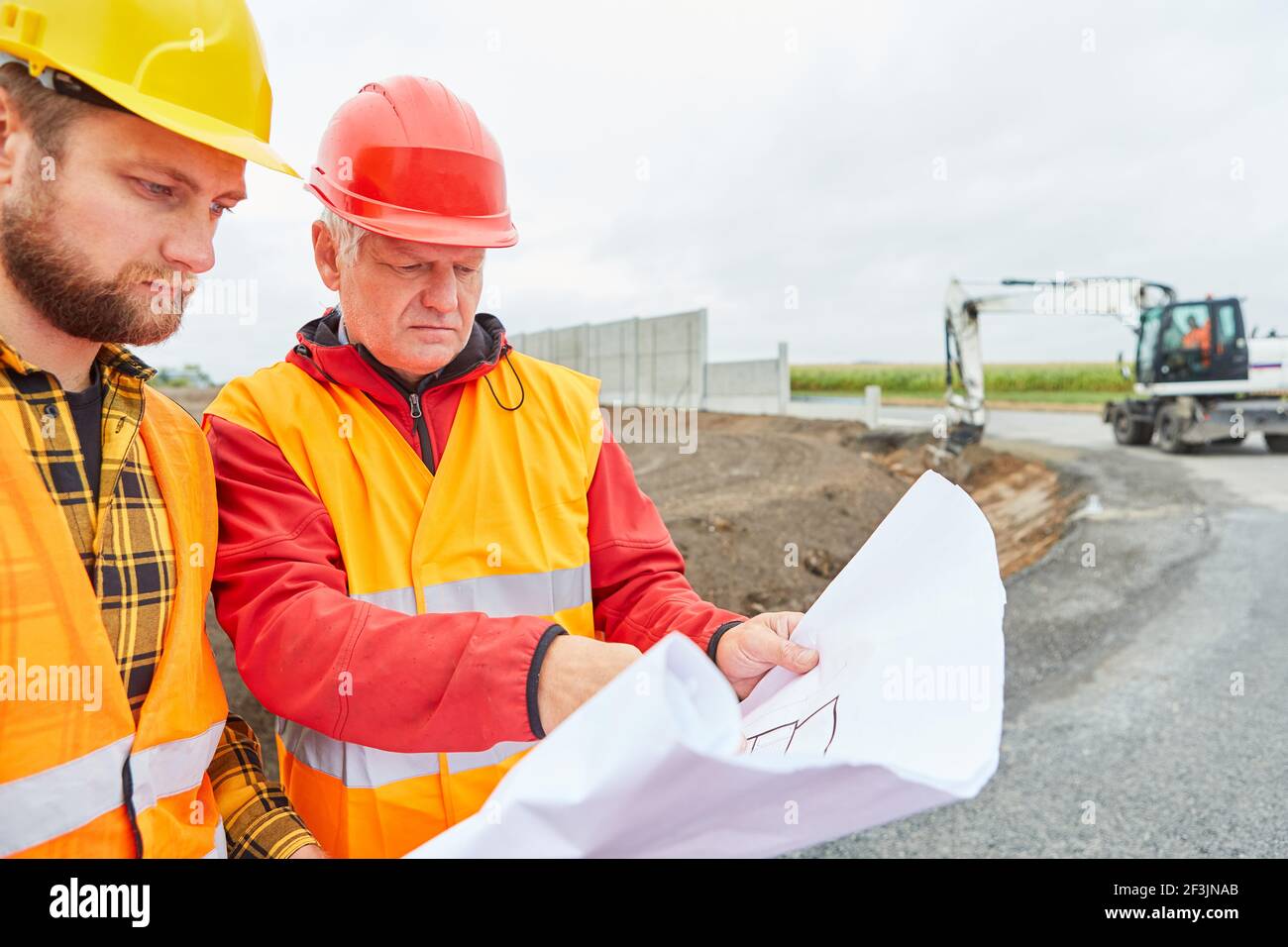 Architect and construction worker with floor plan when building a house ...