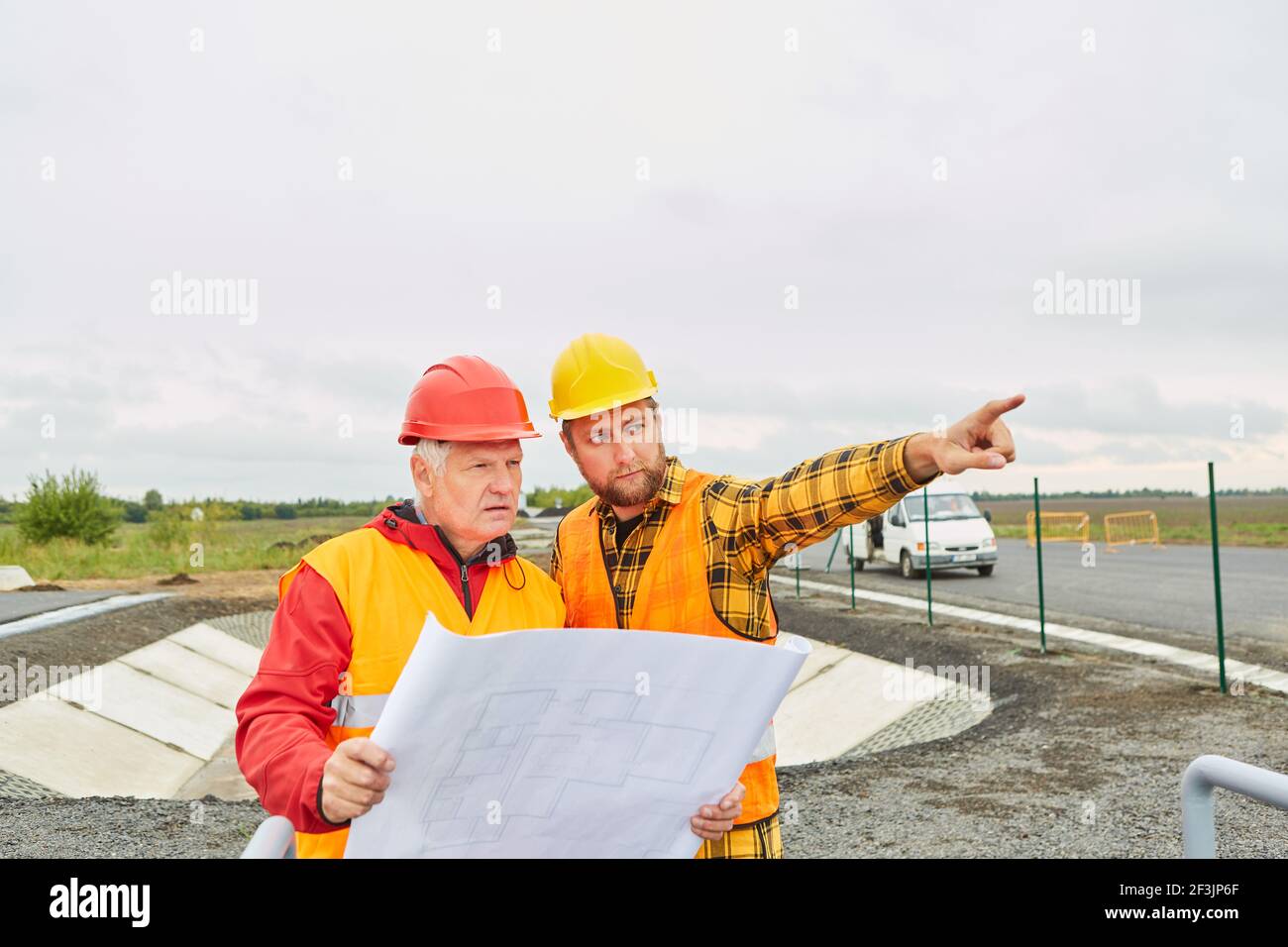Architect and foreman with construction drawing for the development of ...