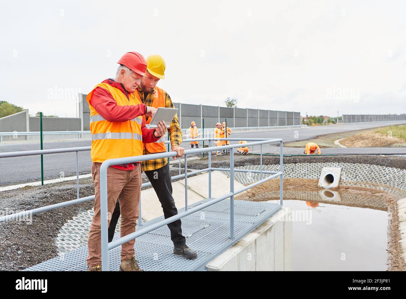 Construction workers inspecting a construction structure on a road ...