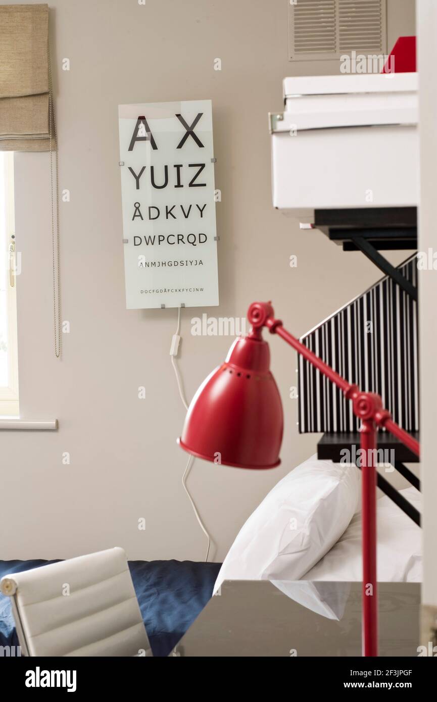Bedroom with red reading lamp, shelves and optician letters wall lamp ...