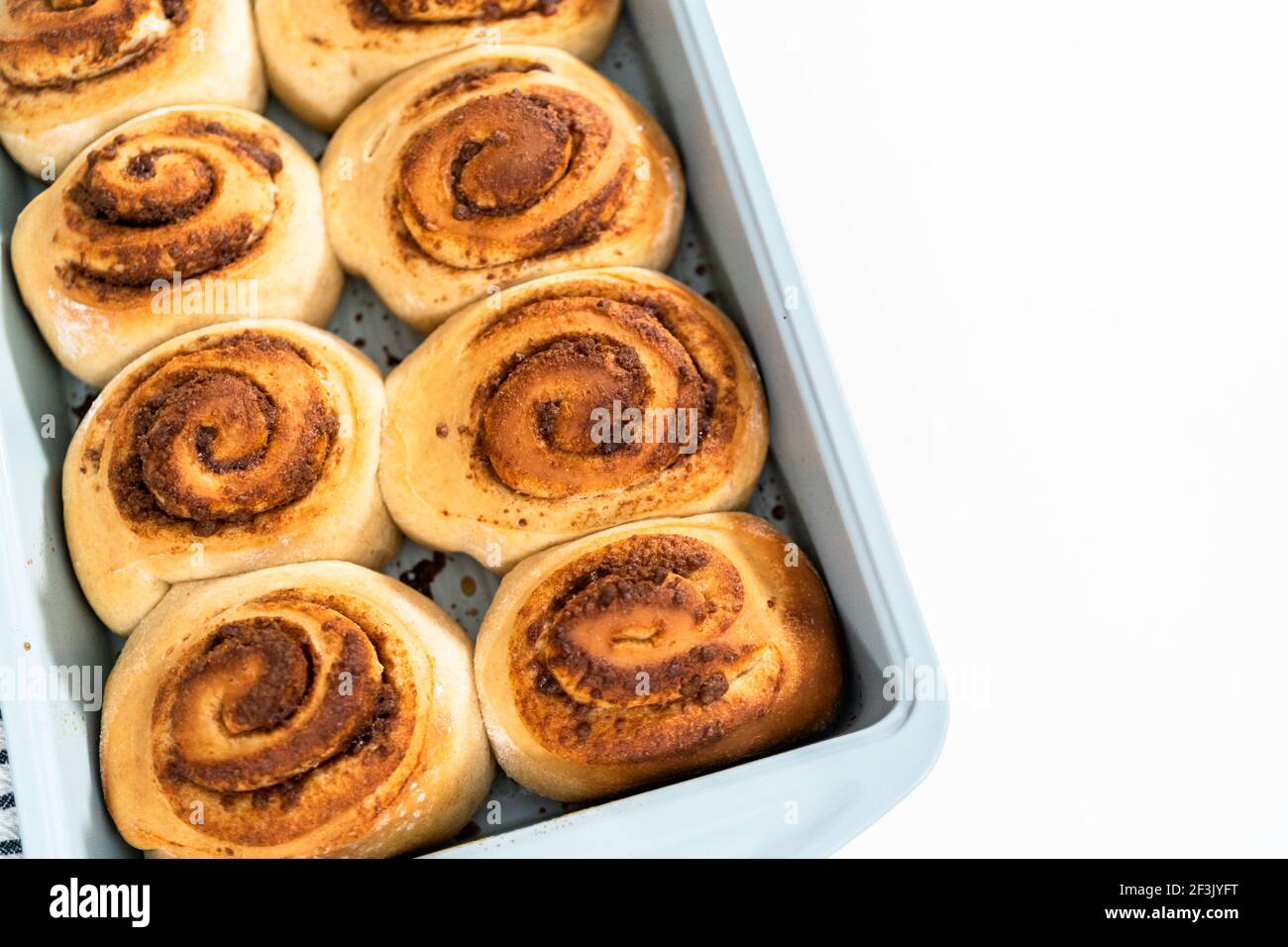 Freshly baked cinnamon rolls in a blue baking pan Stock Photo - Alamy