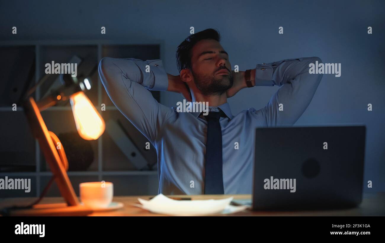 tired businessman stretching while working late Stock Photo - Alamy
