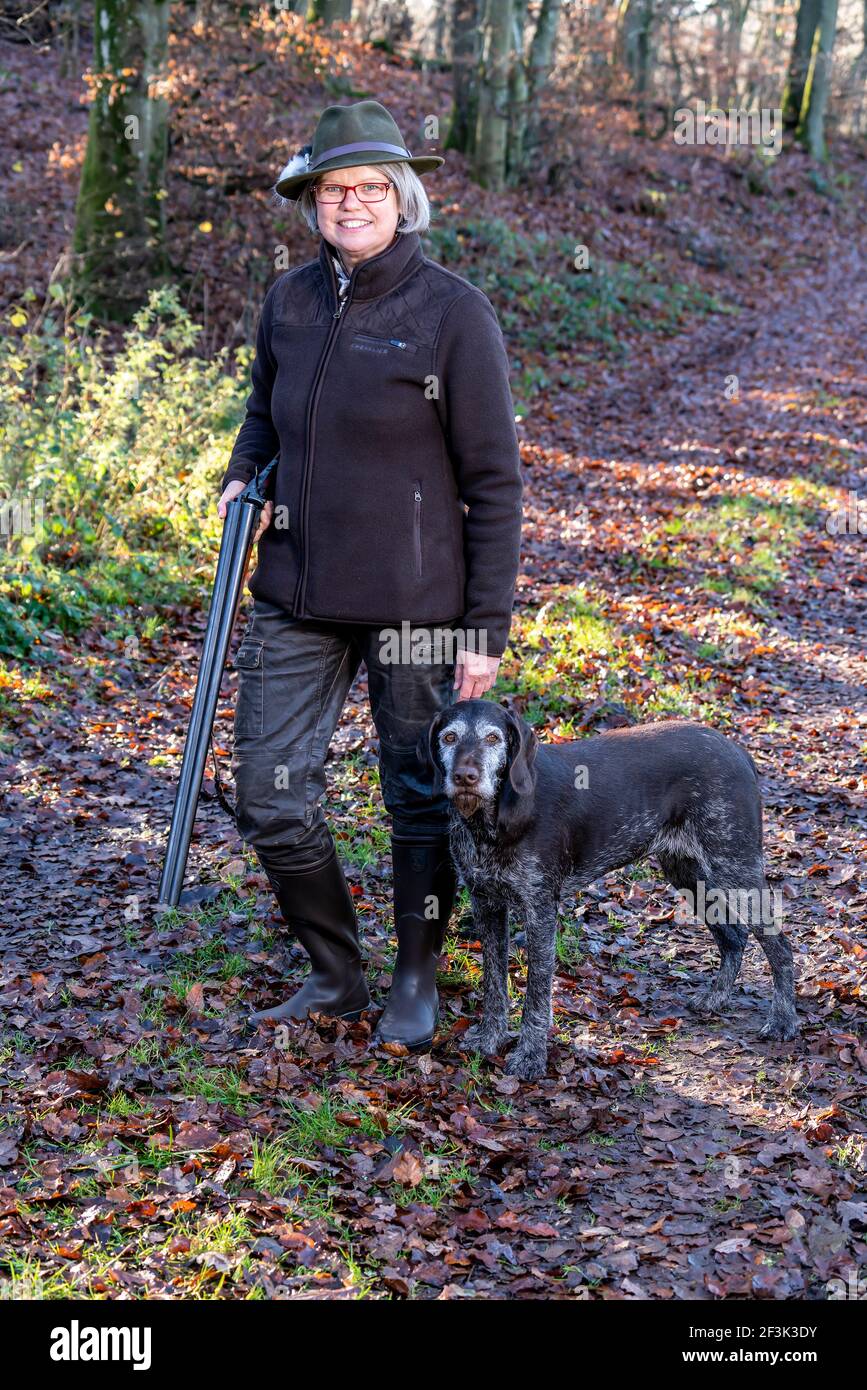 Female hunter and German Wirehaired Pointer in a forest. Germany Stock ...