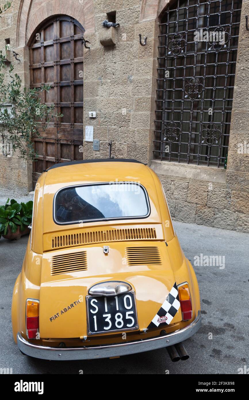 A classic Fiat 500 Abarth car parked in the medieval streets of ...