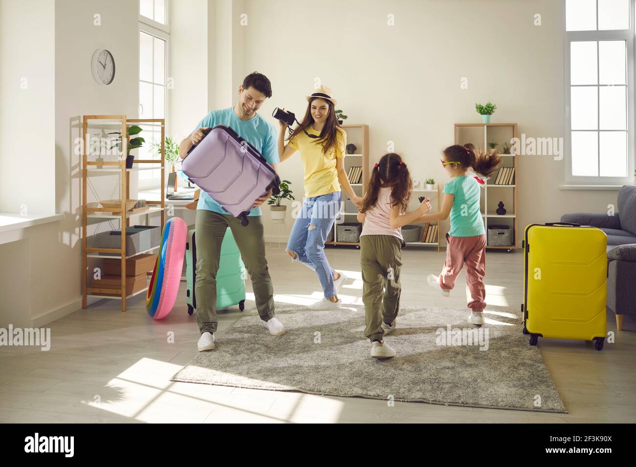 Happy family dancing with travel stuff ready for summer vacation on ...