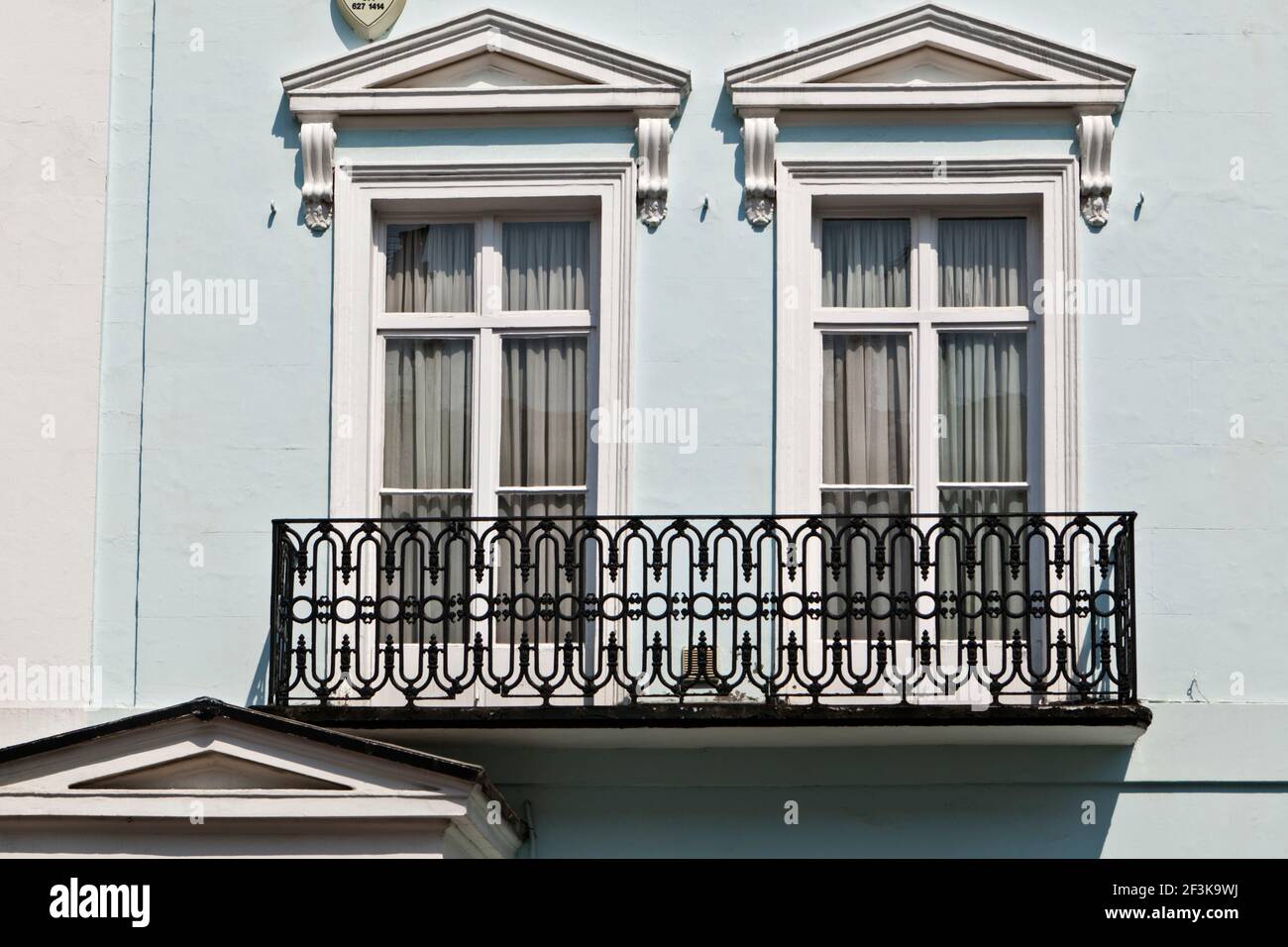 Detail of ornate pediments over central windows and cast iron balcony ...