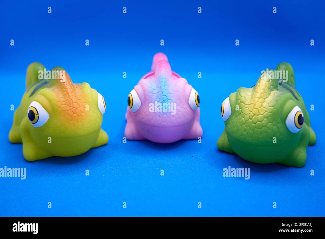 A set of rubber chameleon toys on a blue background Stock Photo - Alamy