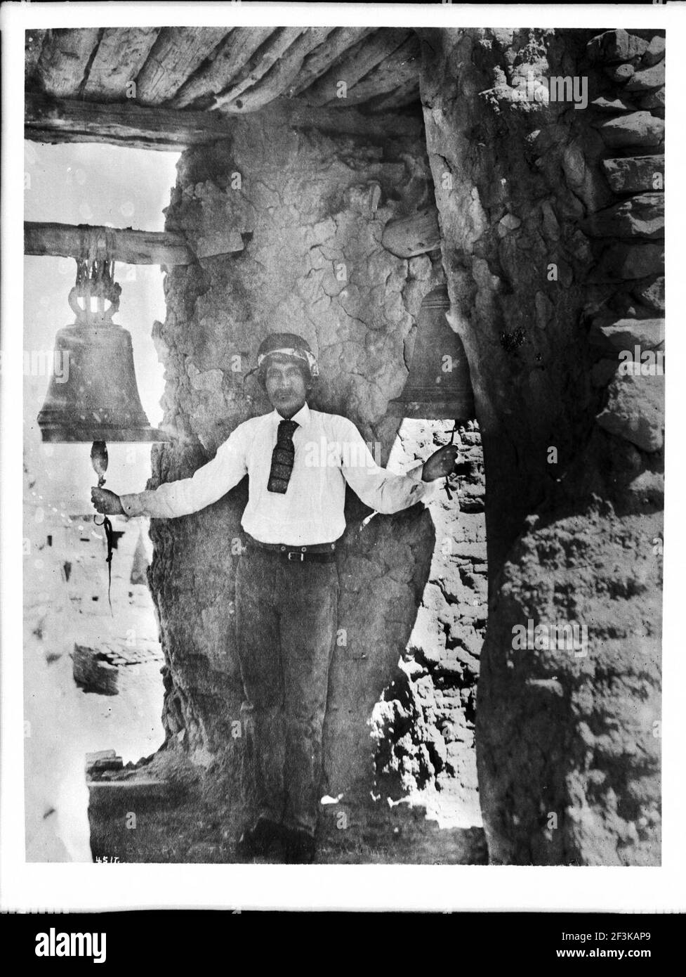 Pueblo Indian bell-ringer in the belfry of the old church, Acoma Pueblo ...