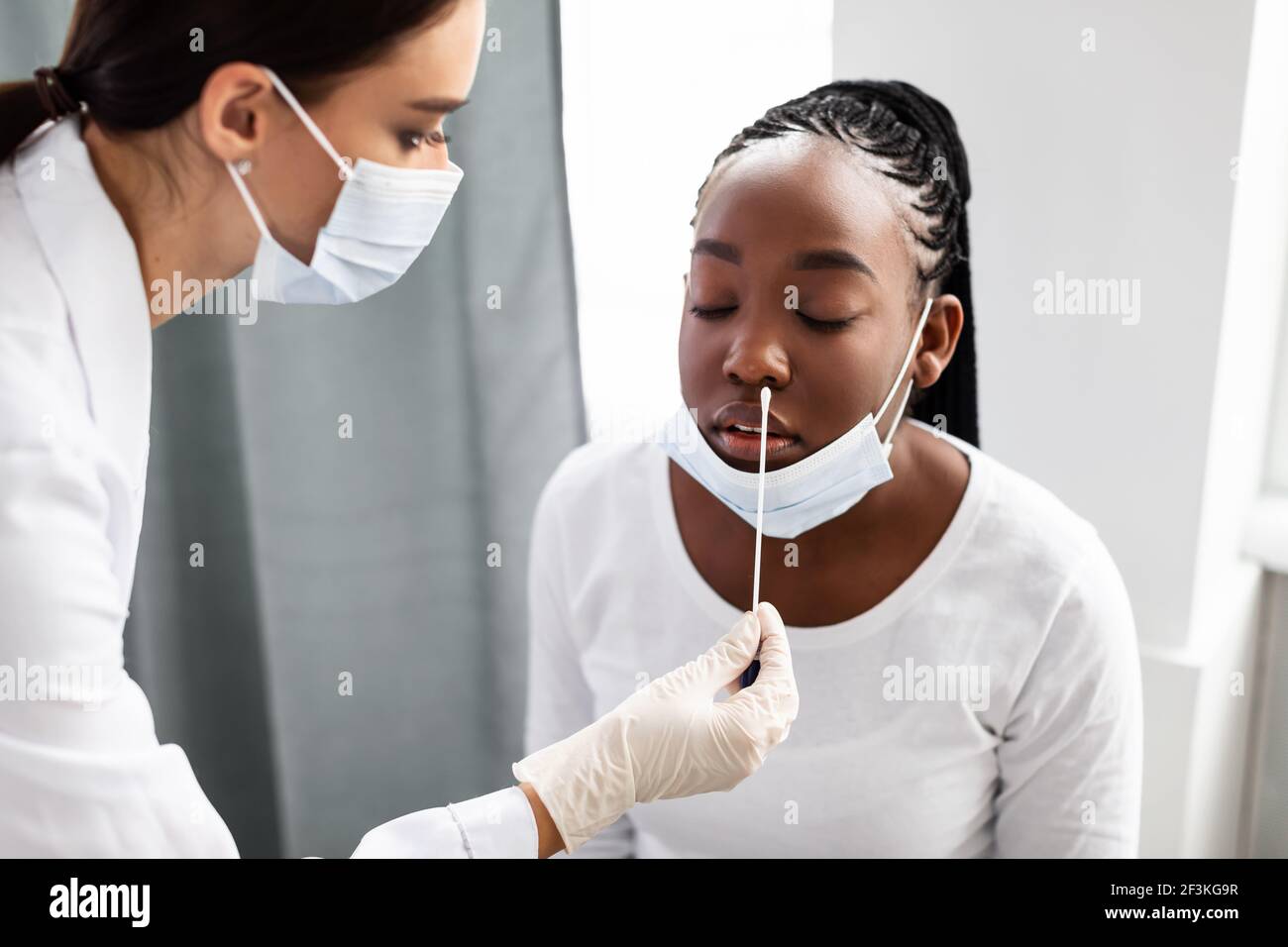 Doctor taking PCR test sample from potentially infected black woman ...