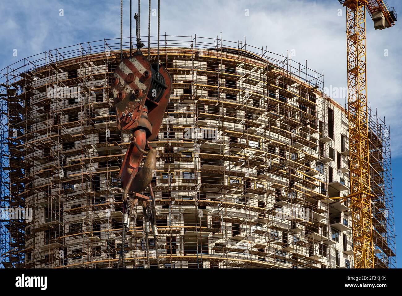 Construction crane hook with multi-storey building under construction ...