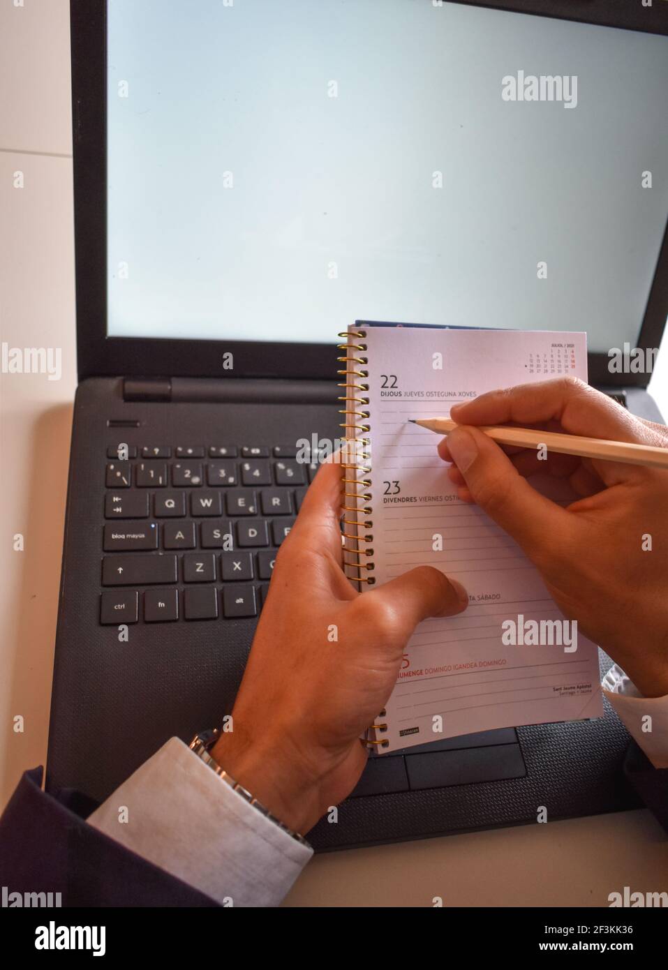 A vertical shot of a businessman entering notes on his planner Stock ...