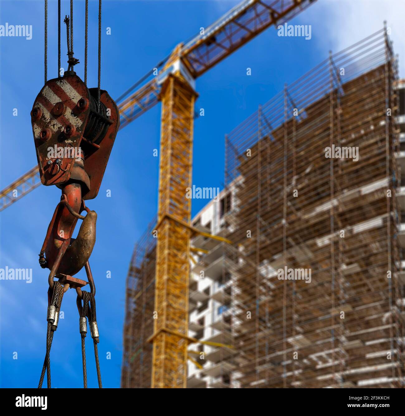 Construction crane hook with multi-storey building under construction ...