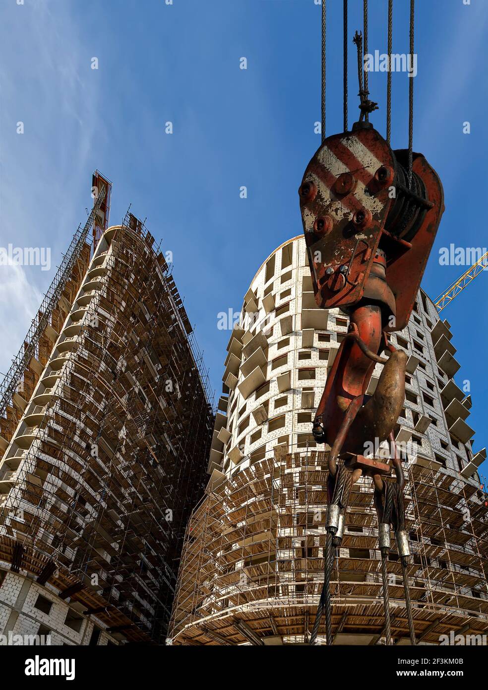 Construction crane hook with multi-storey building under construction ...