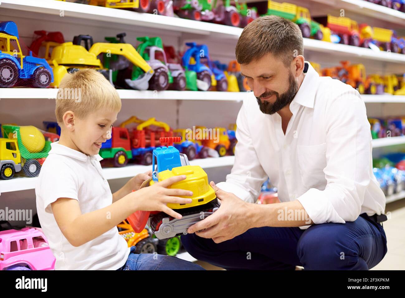 A father with a small child purchasing toys in a children's store Stock ...