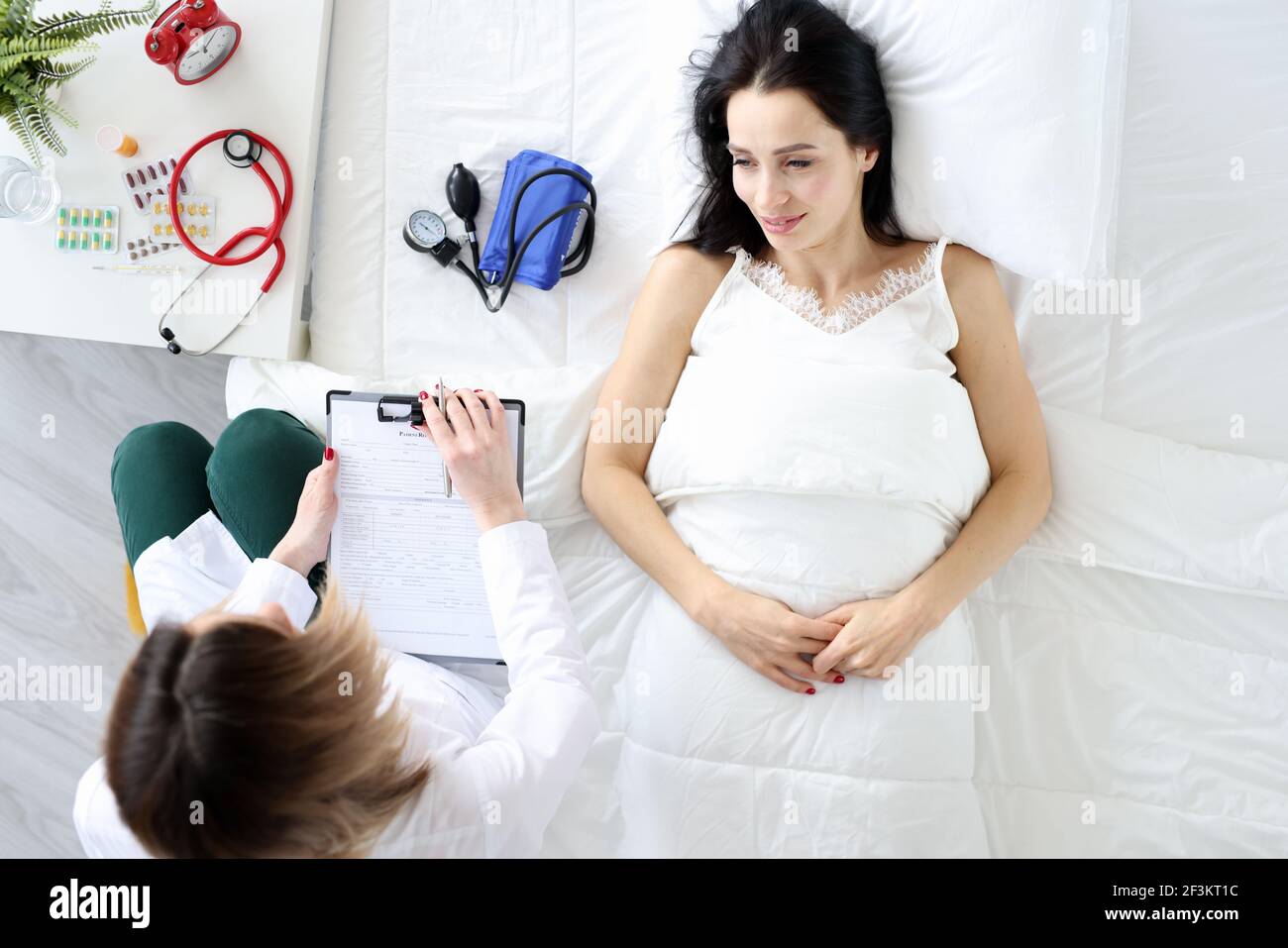 Doctor examining patient in bed at home top view Stock Photo - Alamy
