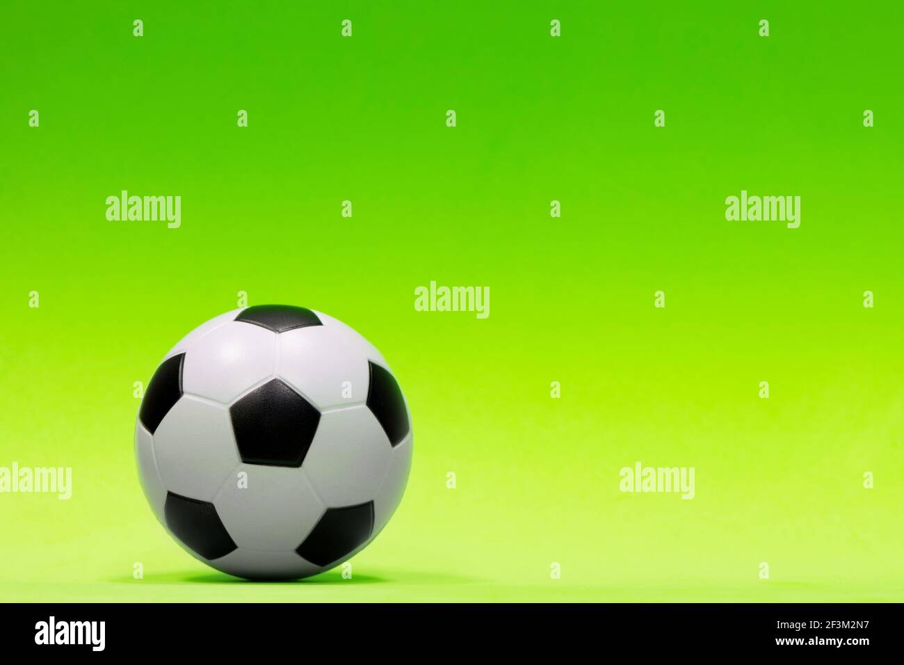 Soccer ball isolated against a plain green background with gradual ...