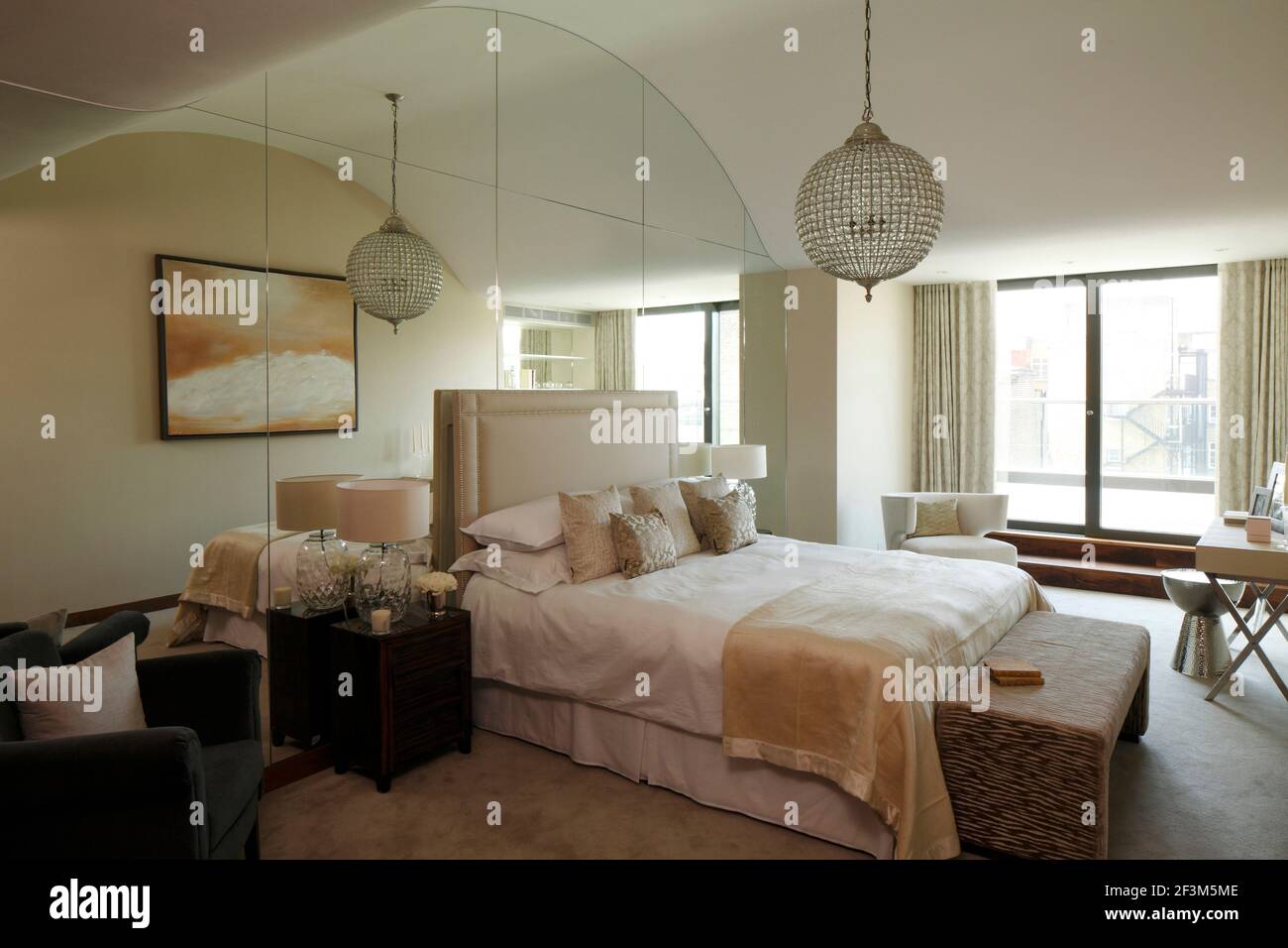 Master bedroom with mirrored wall and curved ceiling (lights off) in UK ...