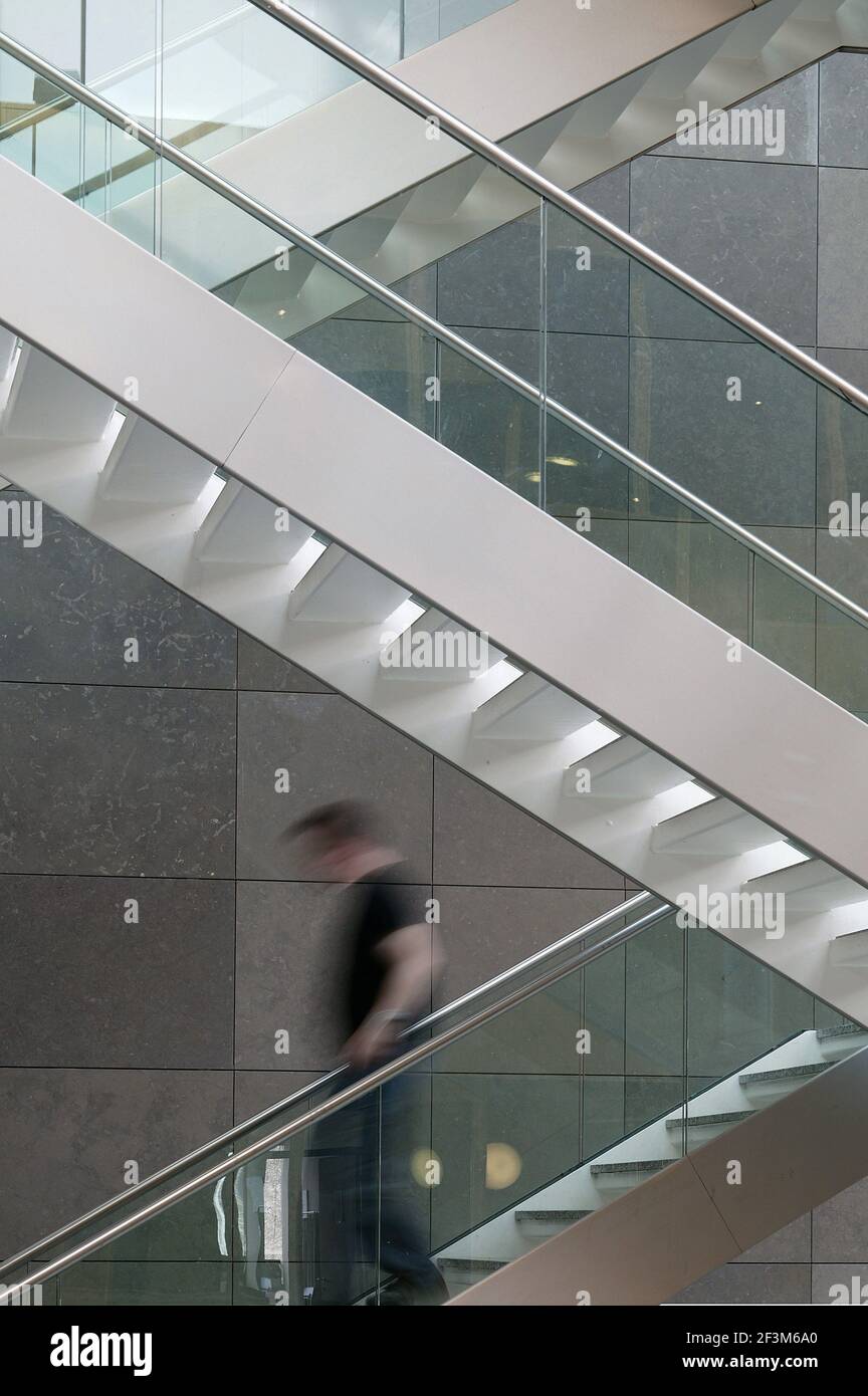 Man walking down staircase, UK Stock Photo - Alamy