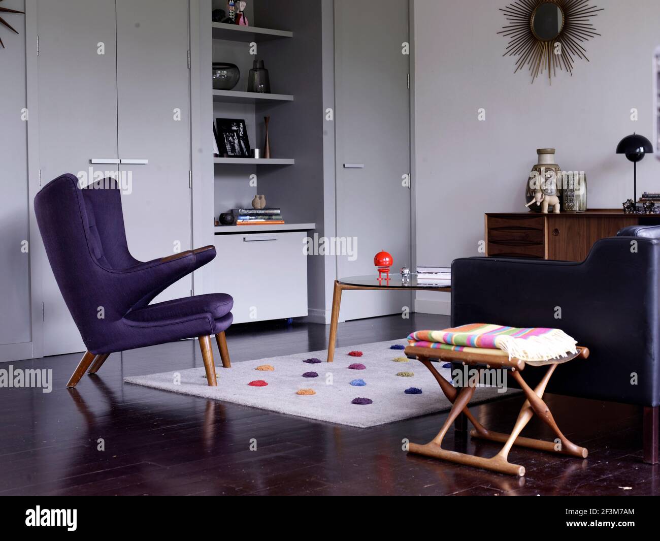 Living room with armchair and built-in cupboards in residential home ...
