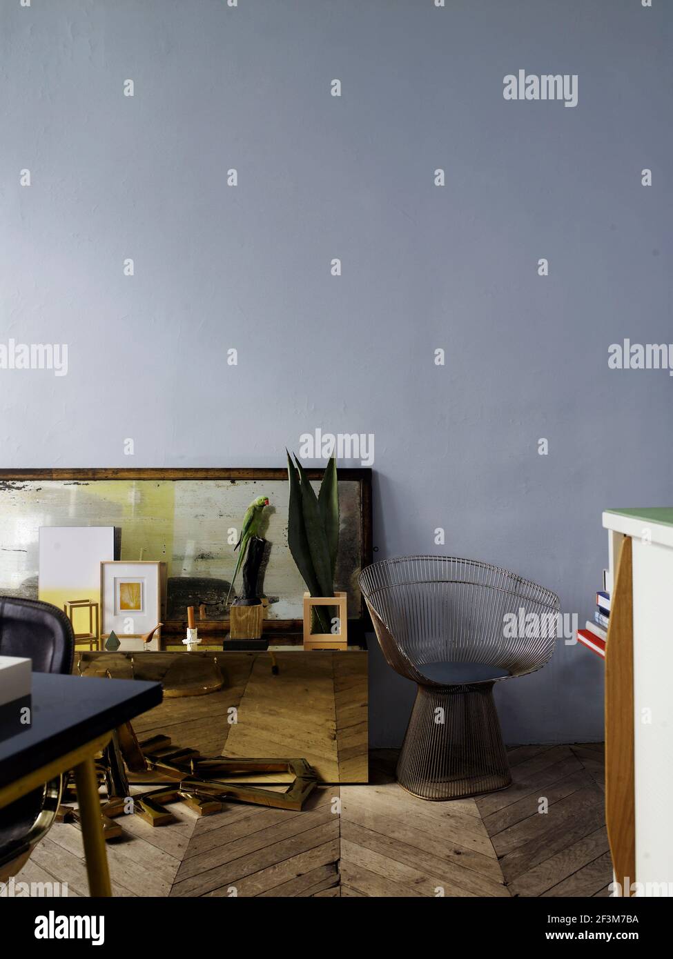 Wire armchair in room with pale blue wall in residential apartment ...