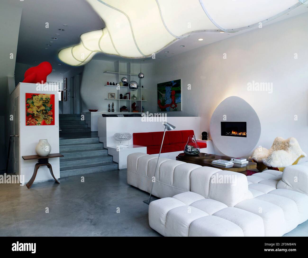 White open-plan, split-level room with organically curved skylight in ...