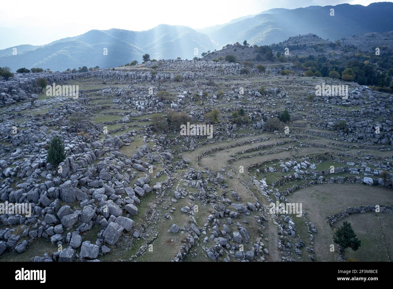 Gray rocks on the field with mountains in the background Stock Photo ...