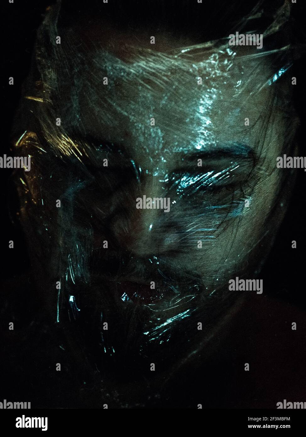 Close-up portrait of a horrible scary living ded man with a plastic on ...