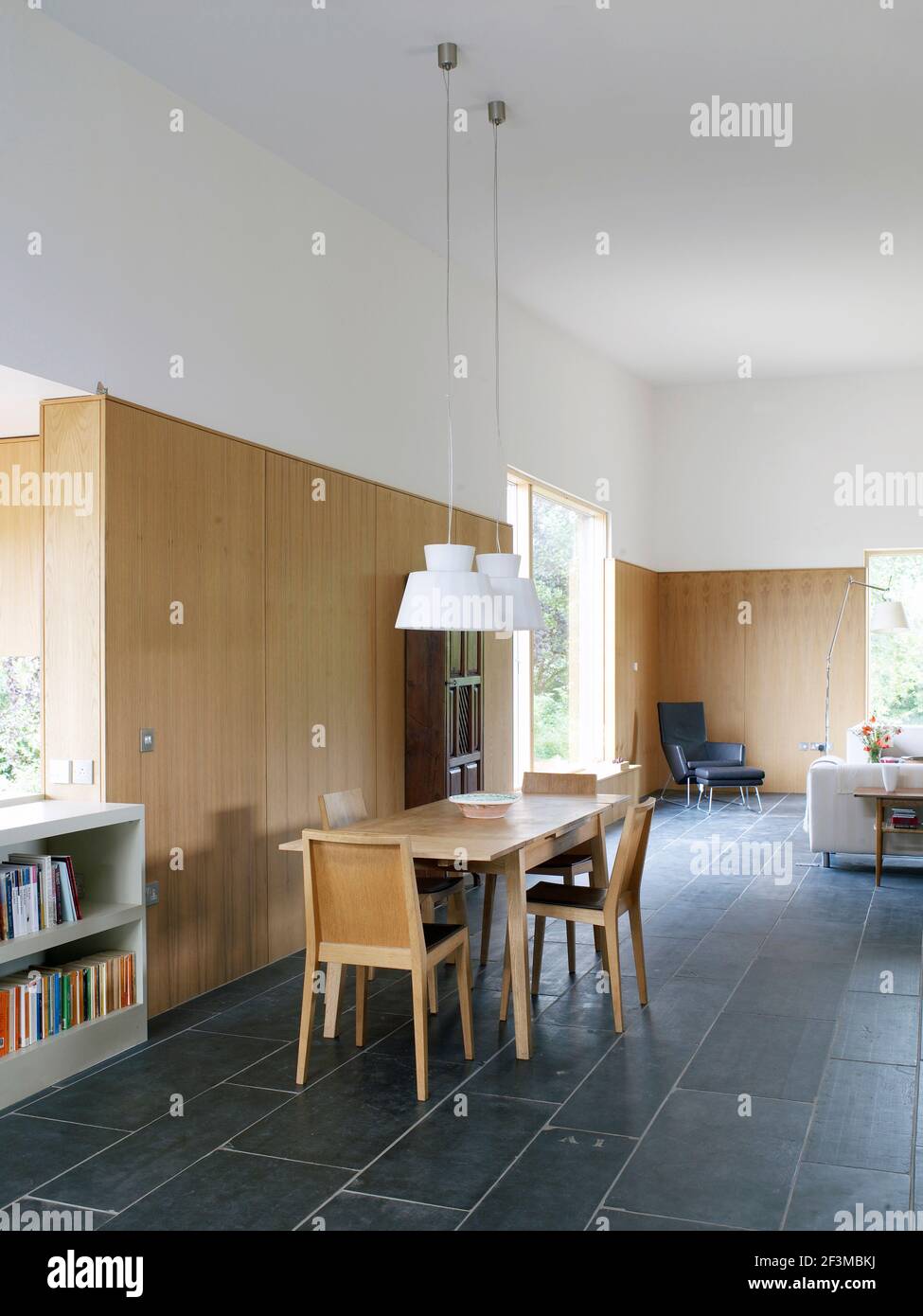 Open plan dining and living area with slate tiled floors, table and ...