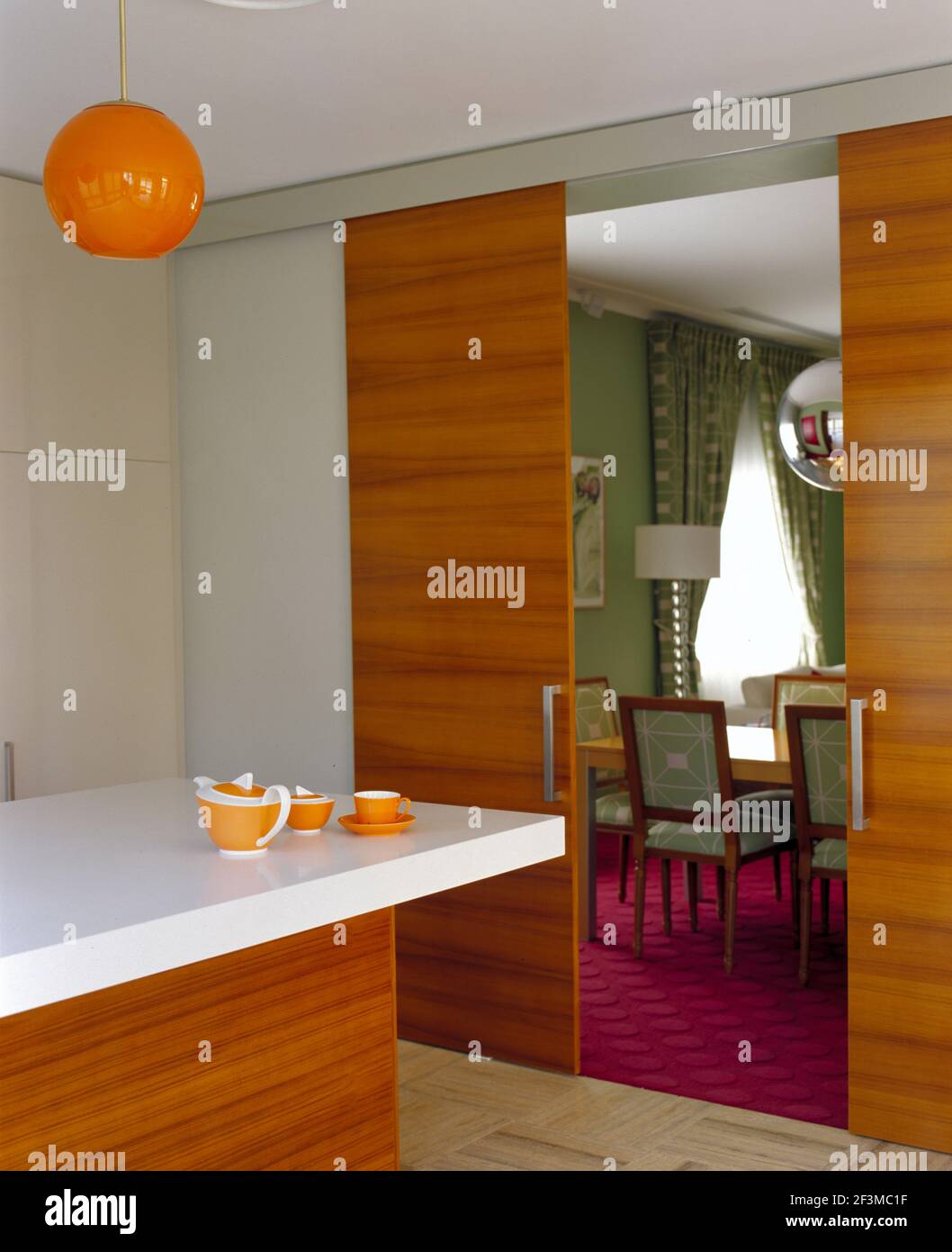 Orange pendant lamp with wooden sliding doors in residential home ...