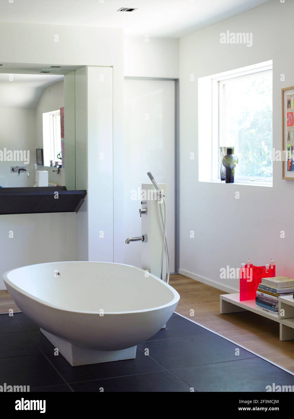 Modern freestanding bathtub and uncurtained window in bathroom of ...