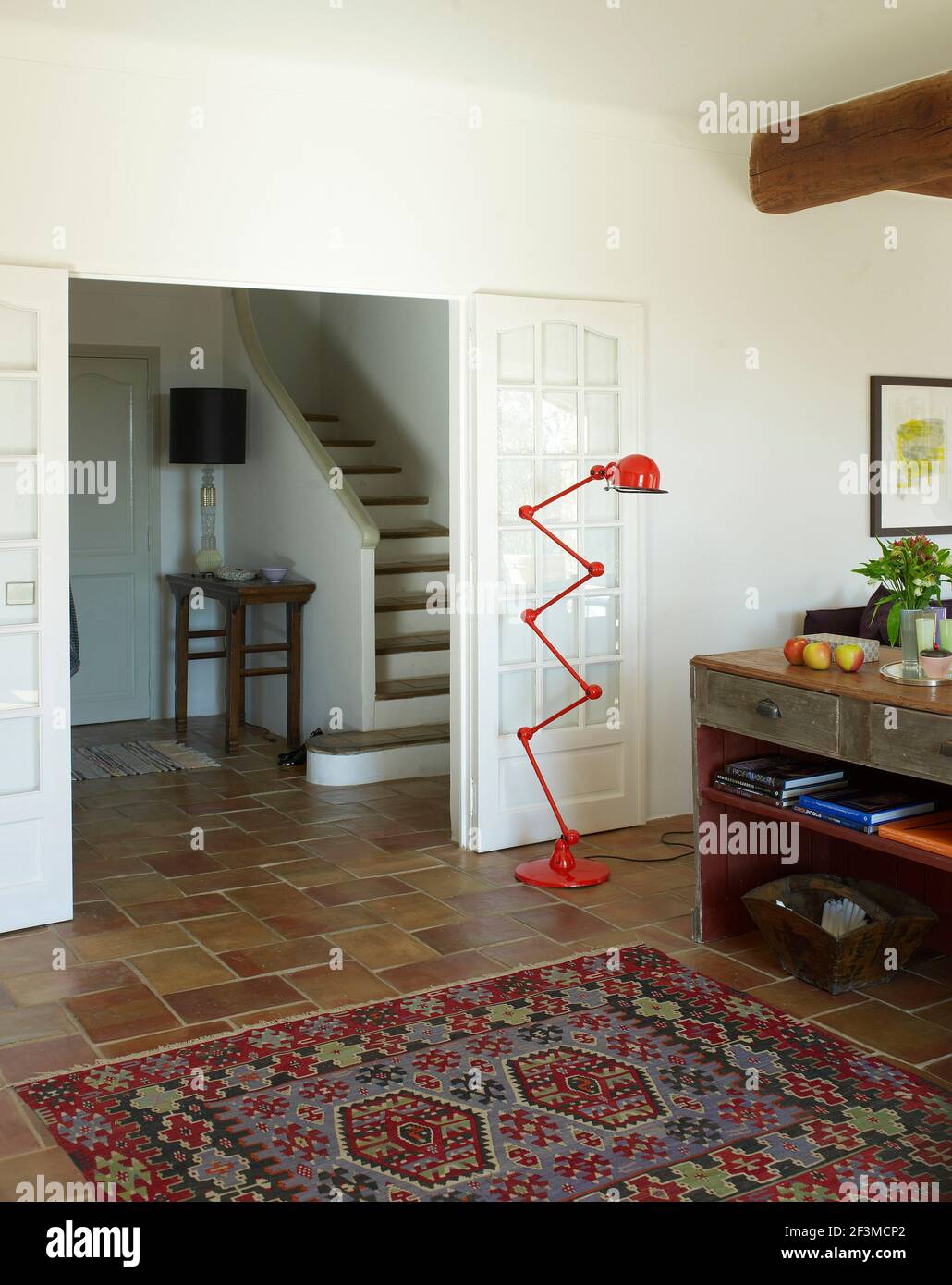 Red metal standing lamp in living room with double open doors with view ...