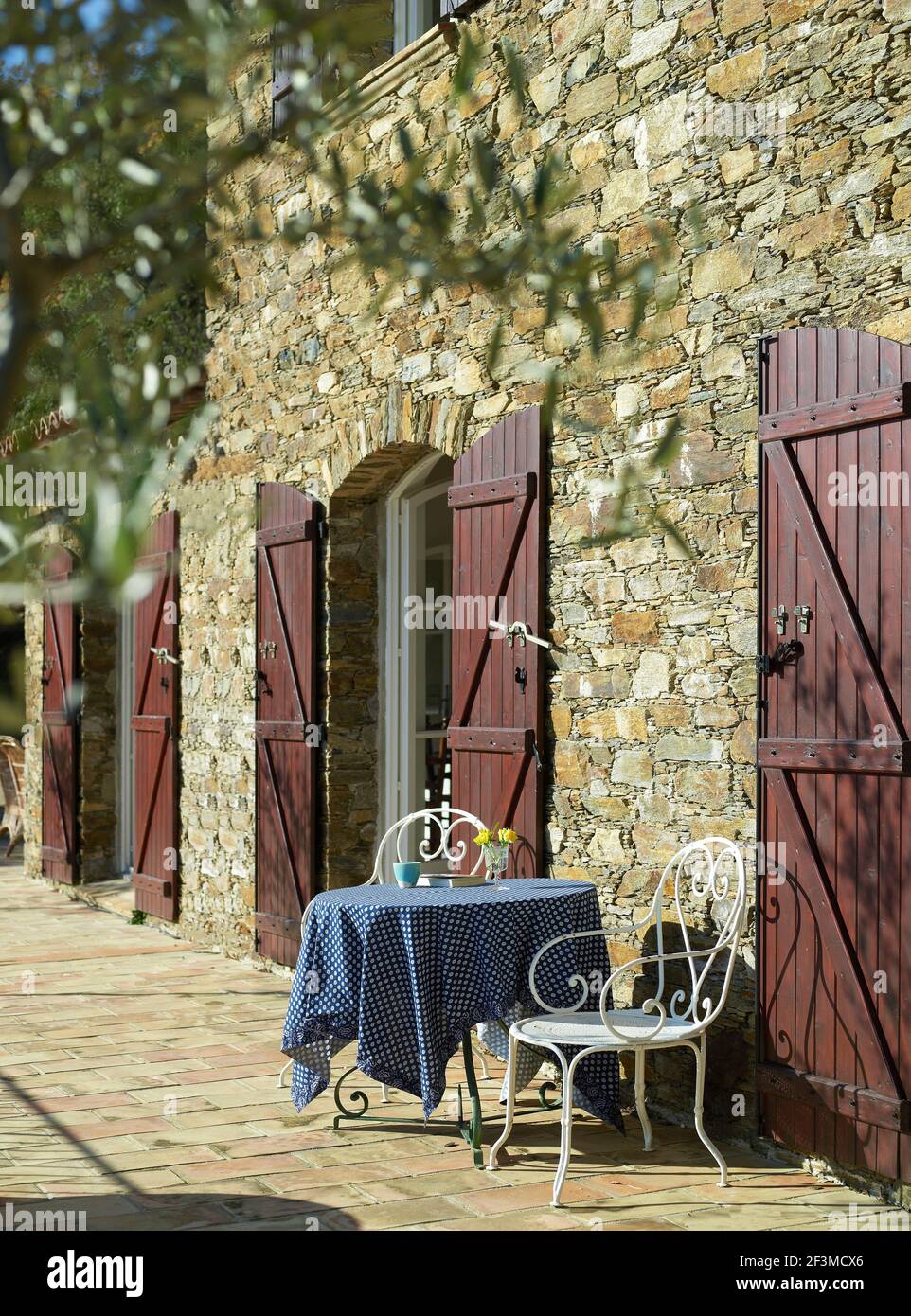 Traditional stone exterior with open double shutters and table for two ...