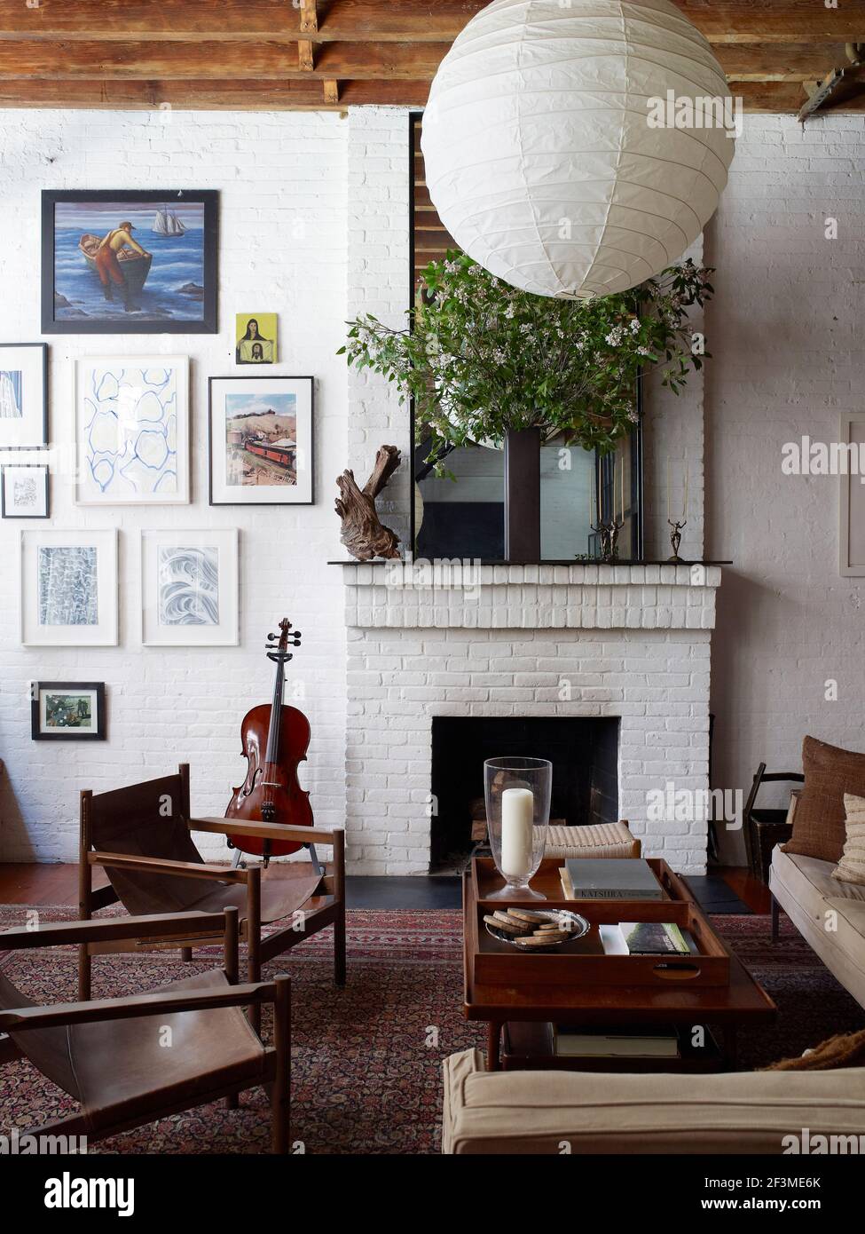 Rustic beamed ceiling living room with cello, artwork, sofas, globe ...