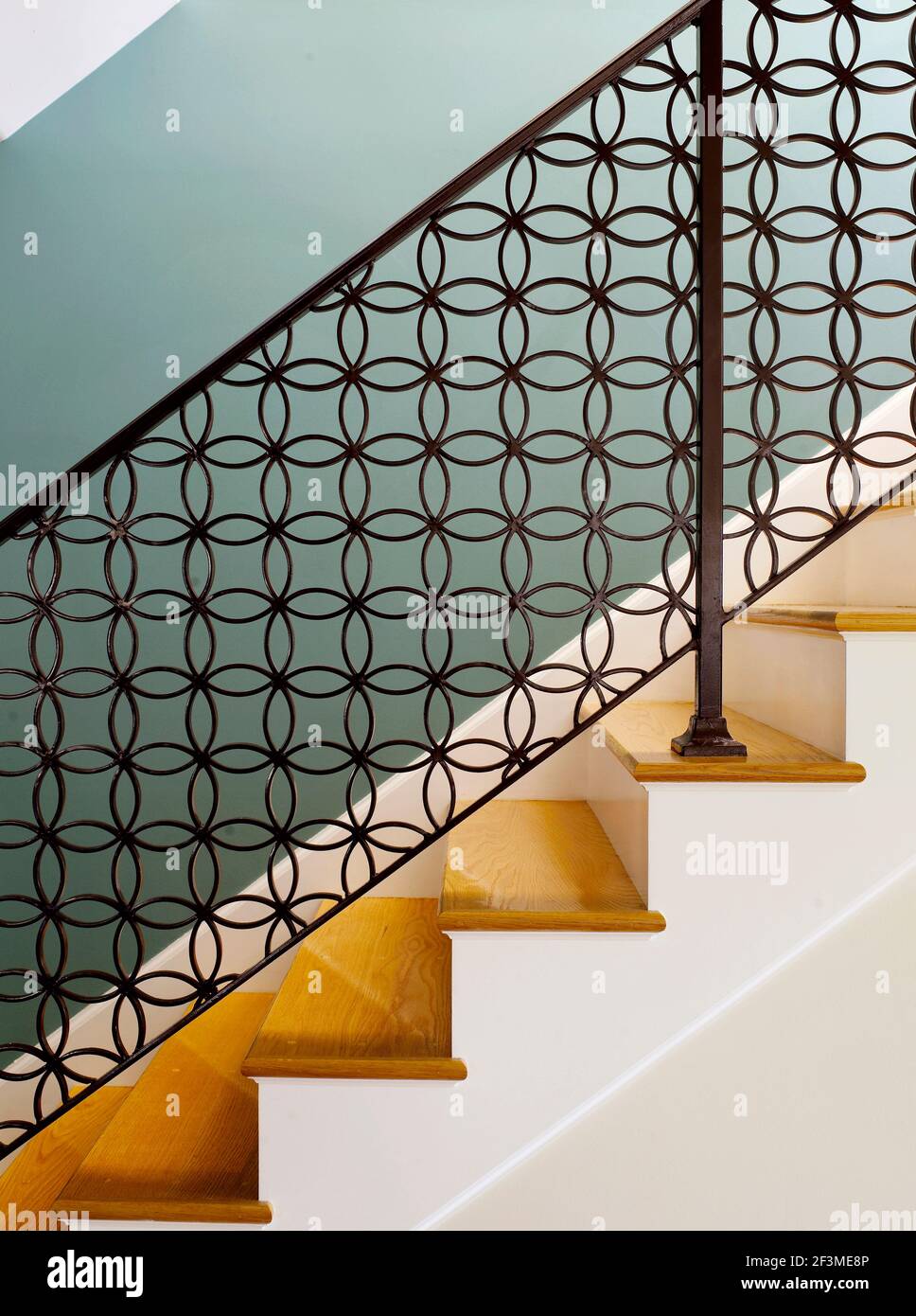 Black geometric balustrades against green wall with stairs in ...