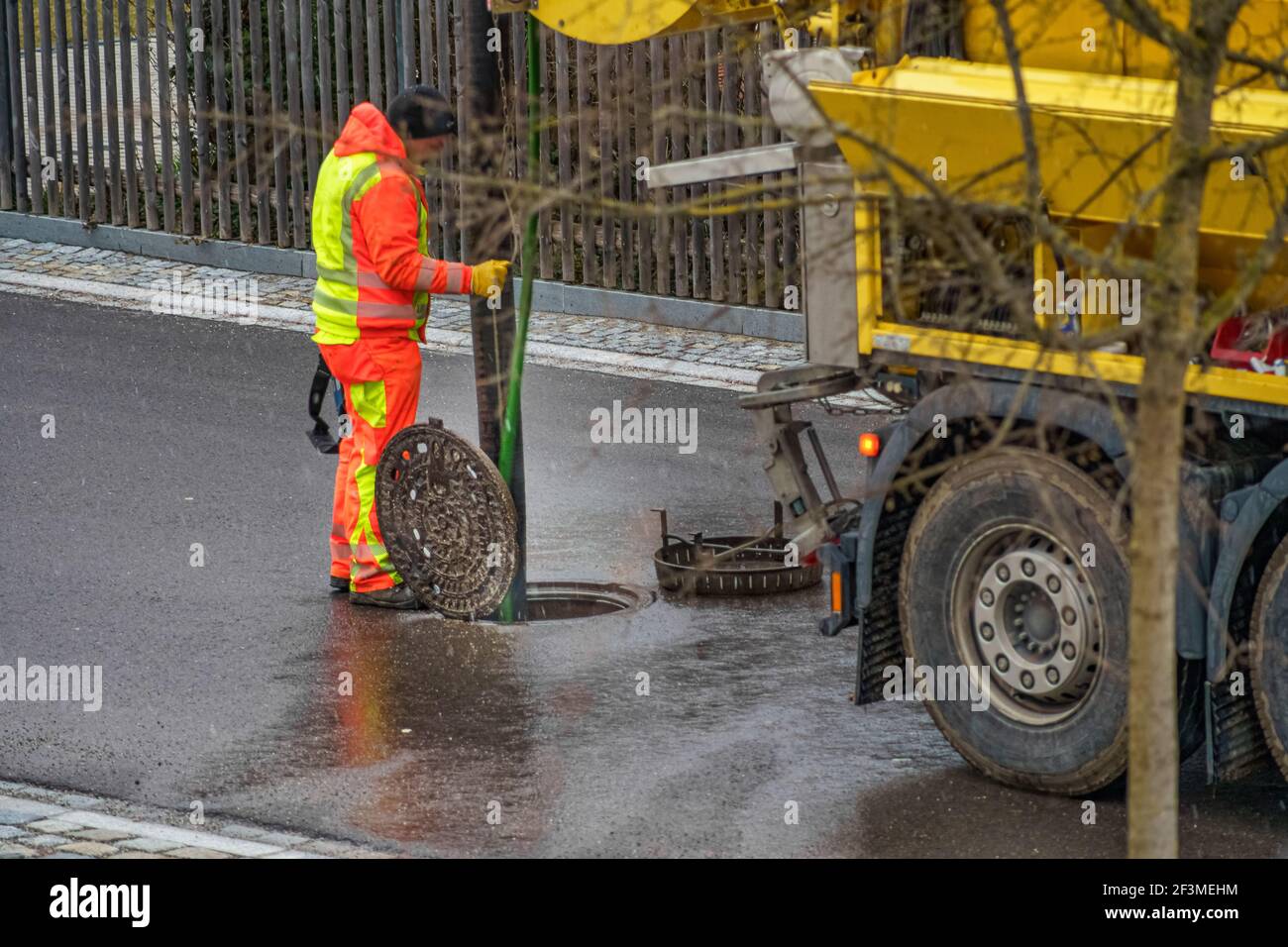 Maintenance at a manhole with a unrecognizable man, working behind the ...