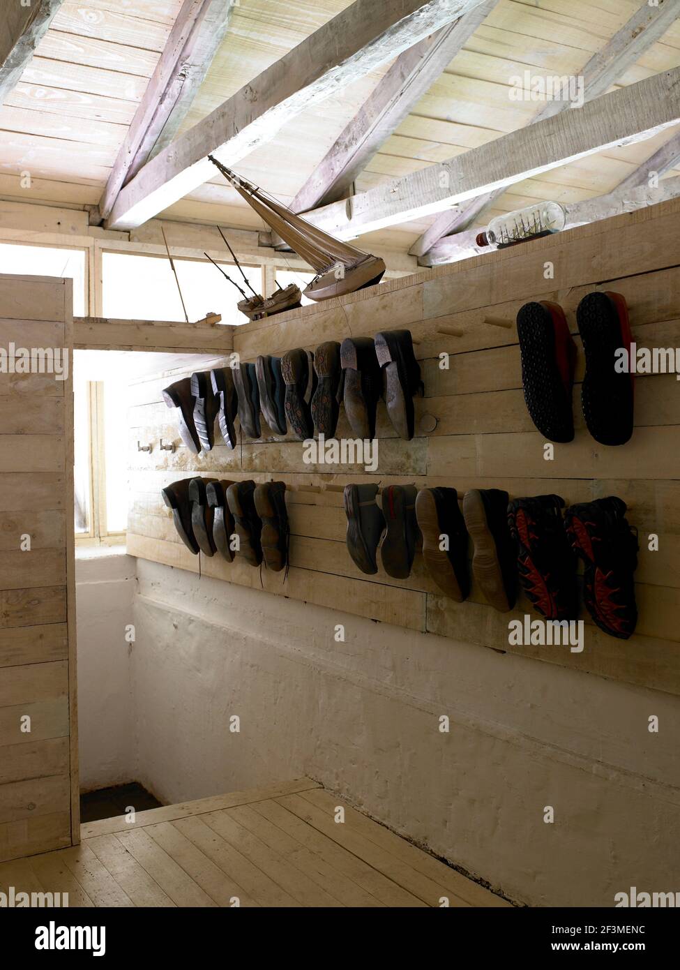 Wall mounted shoe storage on panelled wall in barn conversion, Chile ...