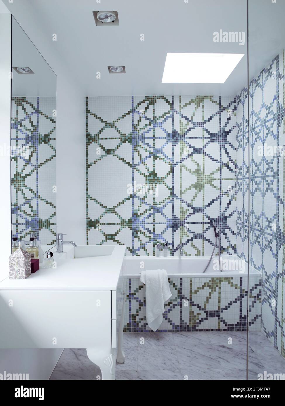 Bathroom with abstract pattern mosaic on two walls and bath panel in ...