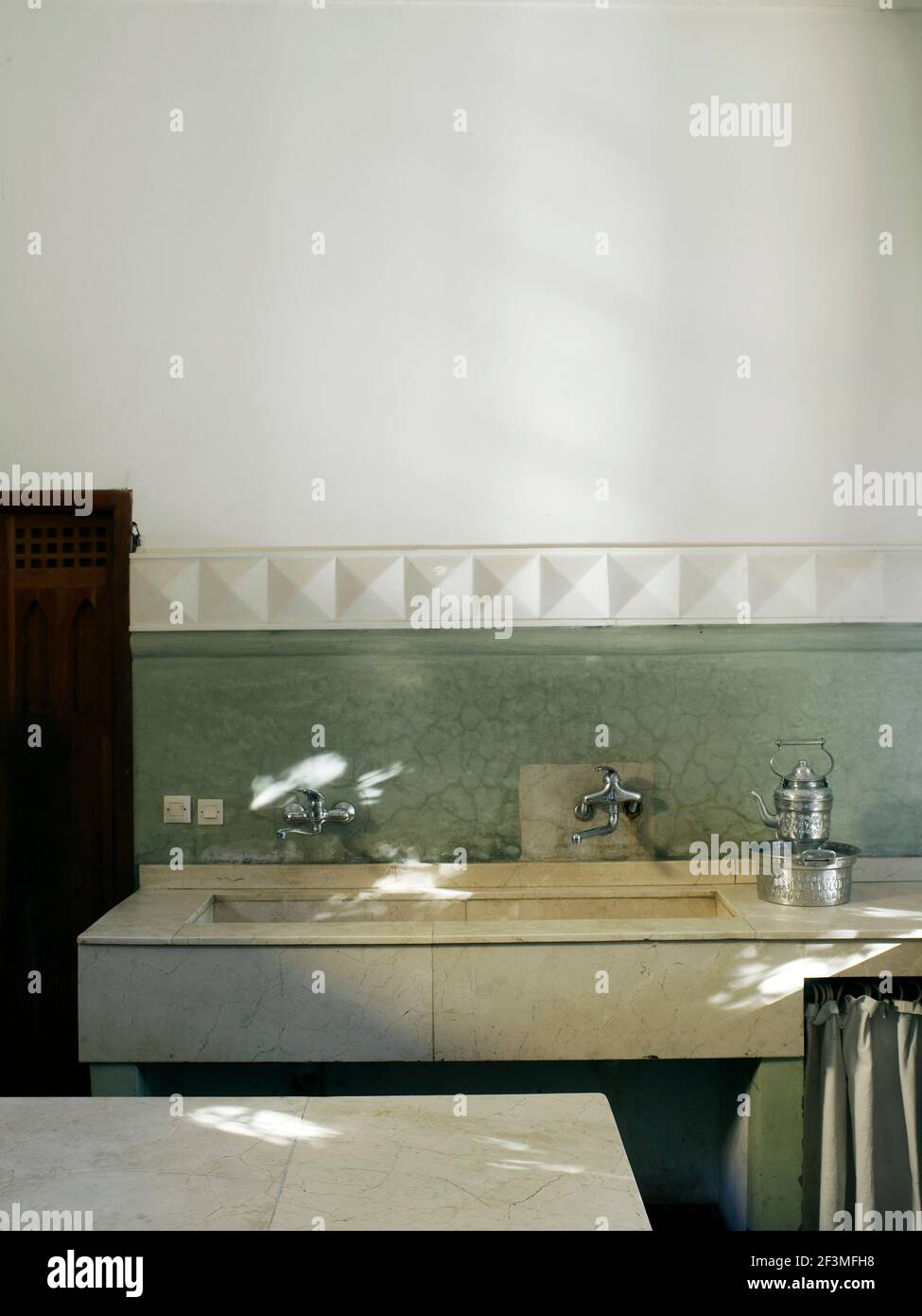 Stone clad double sink with marble splashback in residential house ...
